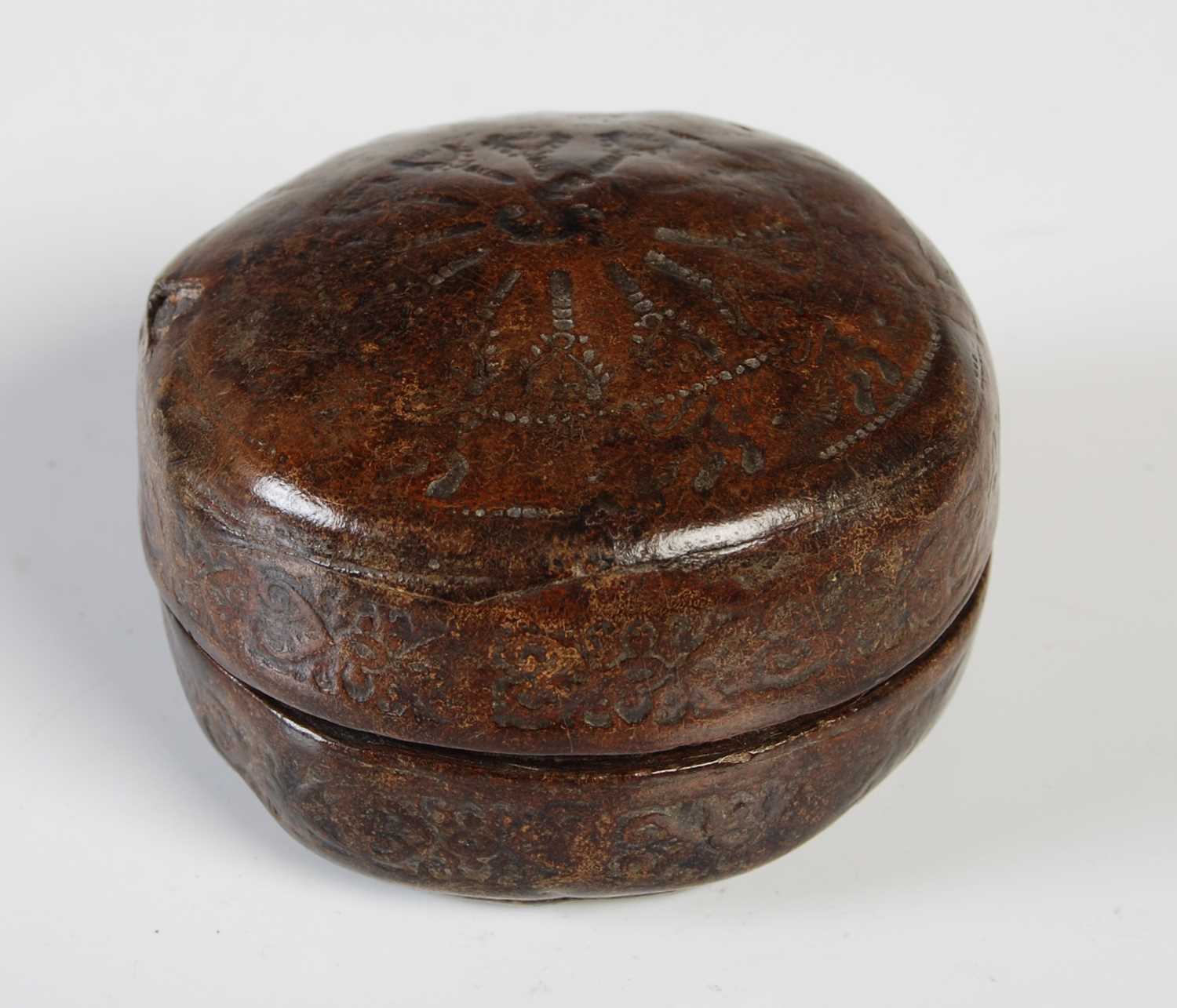 Lot 340 - An early pressed leather circular bun-shaped