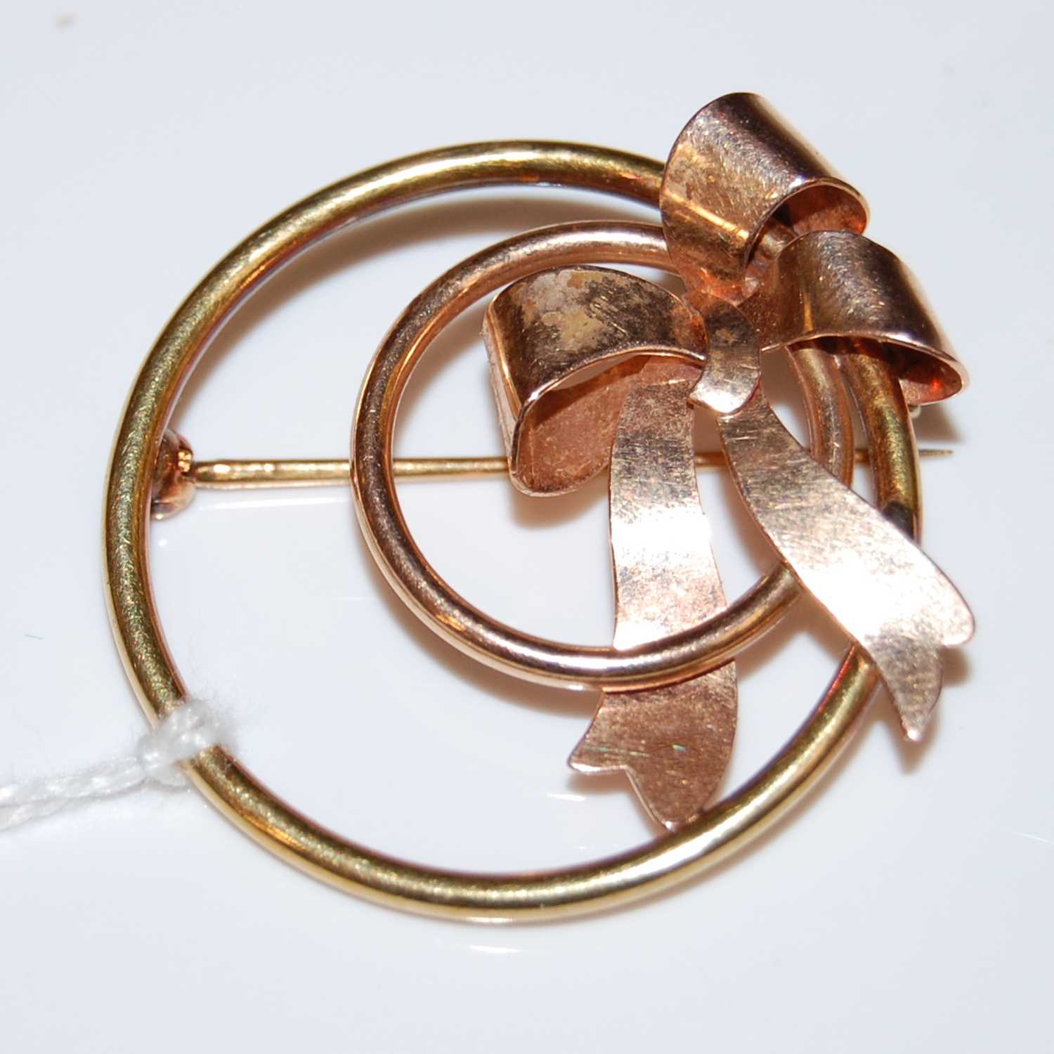 Lot 62 - A yellow metal circular brooch with