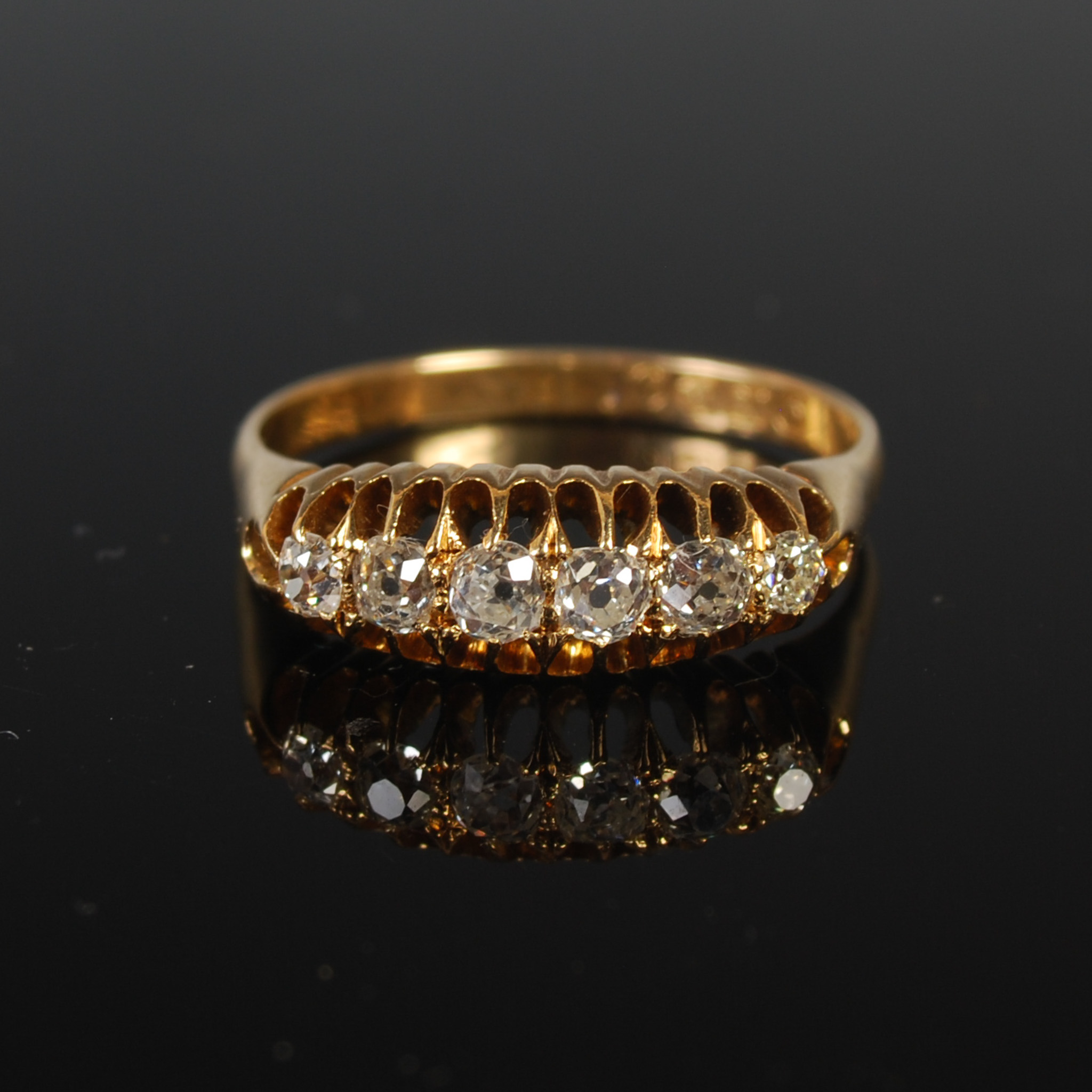 Lot 60 - An 18ct gold and diamond six stone ring, size